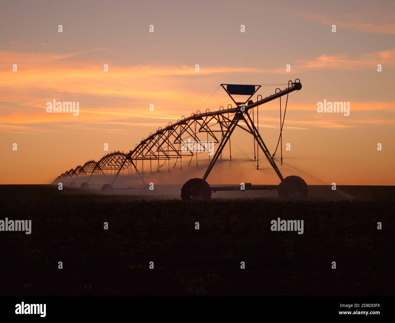 Pivot water system on a farm field at sunset, agriculture irrigation ...