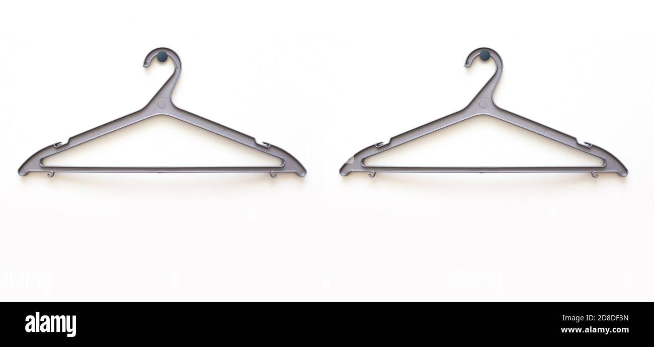 Two white wooden hanger without clothes on background of white wall ...