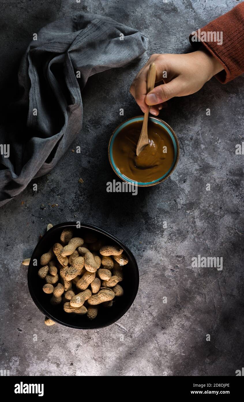 Aerial view photograph of homemade peanut butter in a blue bowl and one ...