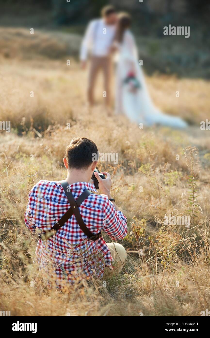 wedding professional photographer takes pictures of the bride and groom ...