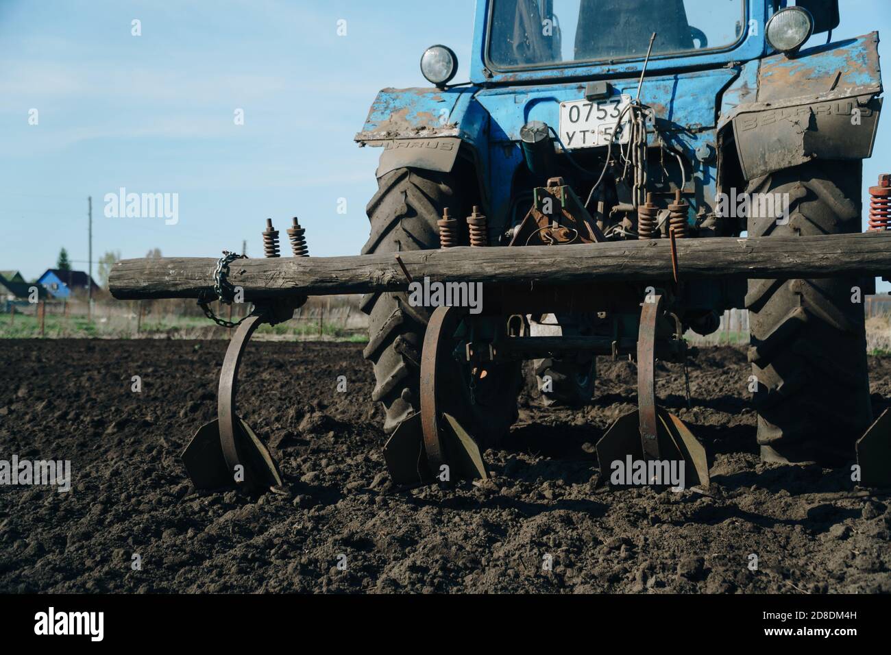 The tractor cultivates and cuts furrows in the field Stock Photo - Alamy