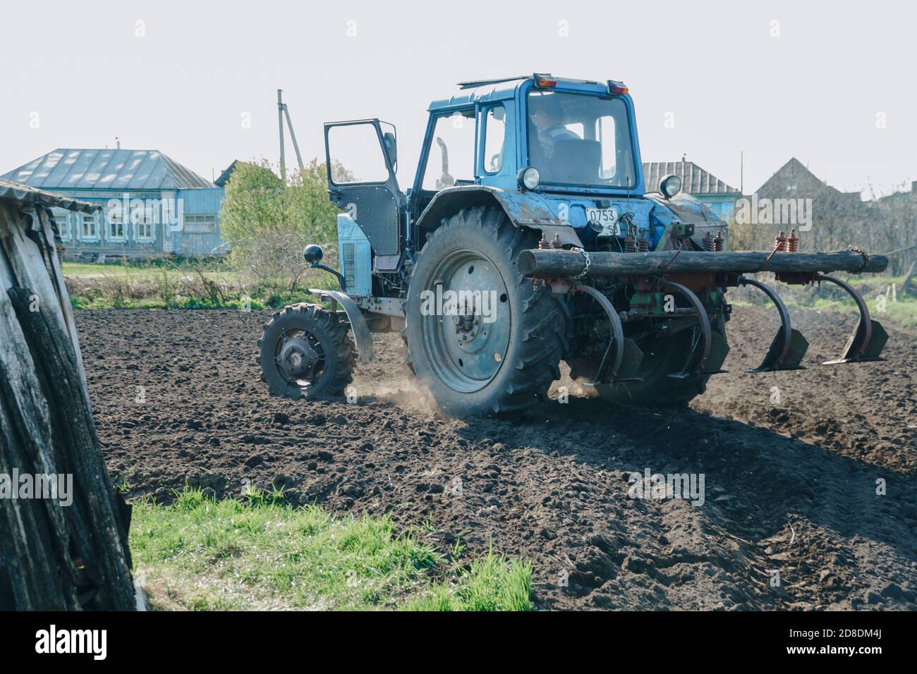 The tractor cultivates and cuts furrows in the field Stock Photo - Alamy