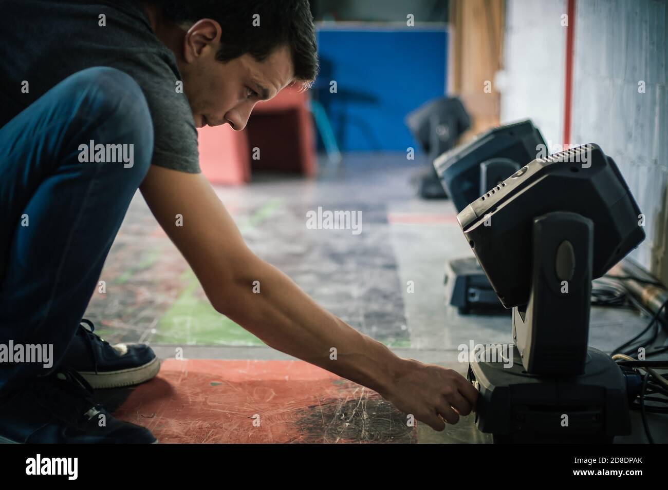 Theater lighting technician electric engineer adjusting focus of ...