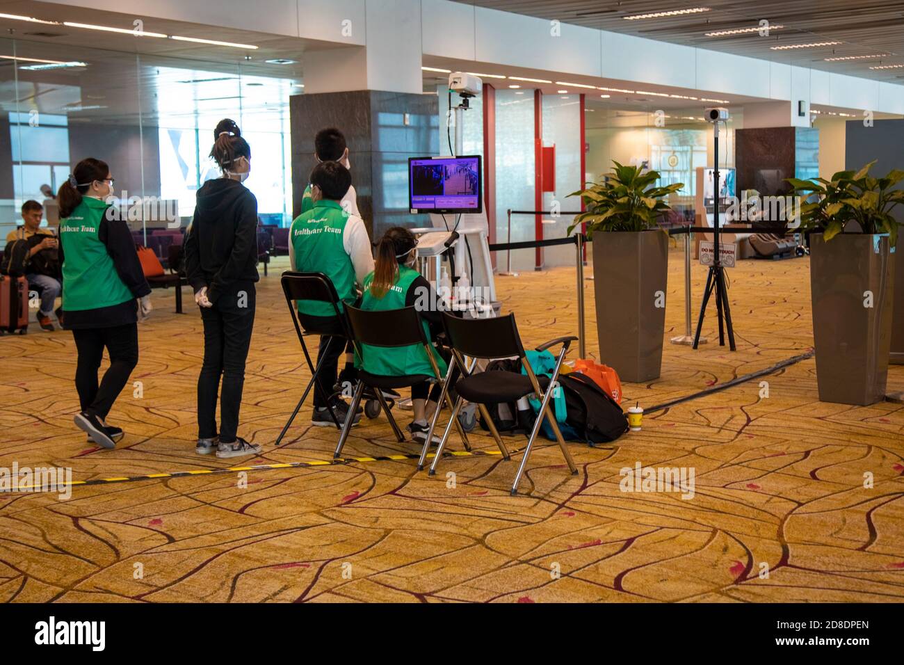 SINGAPORE - JULY 21. 2020: Changi airport staff sit behind a thermal ...