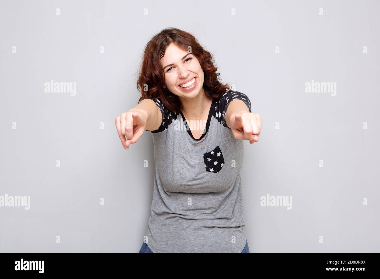 Portrait of cheerful young woman pointing fingers Stock Photo - Alamy