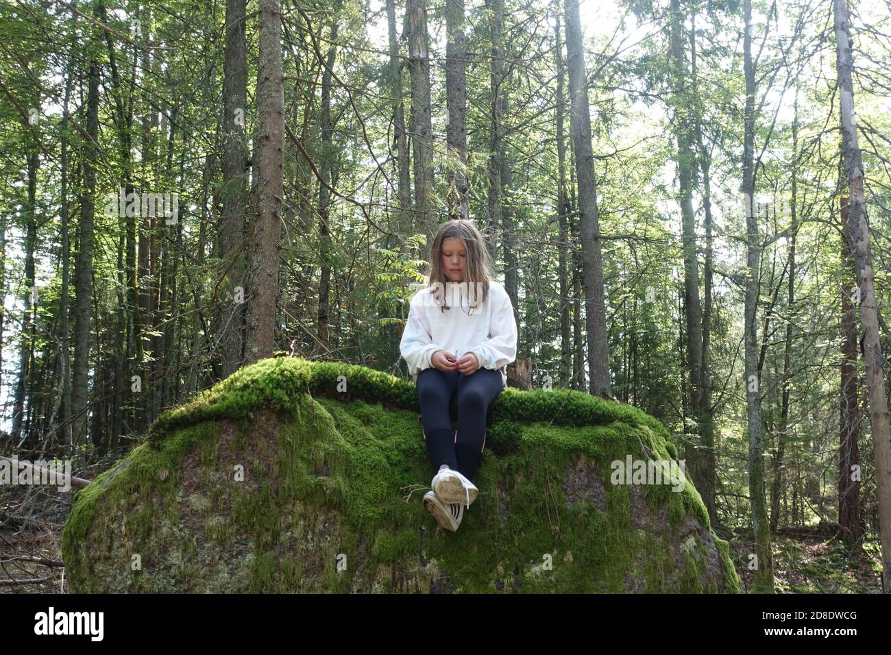 girl sitting on a big rock in the forest Stock Photo - Alamy