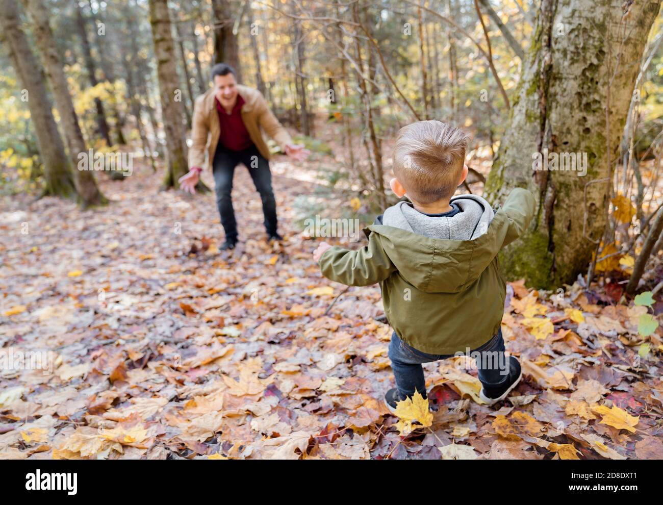 son and her father in the autumn season in park play hideout Stock ...