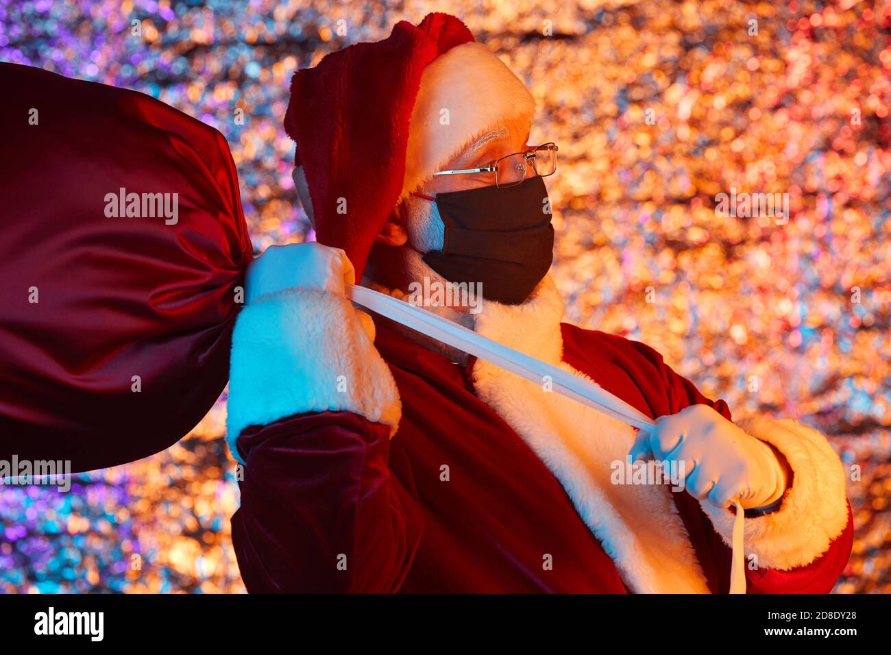 Santa Claus in protective mask carrying big bag he congratulating ...