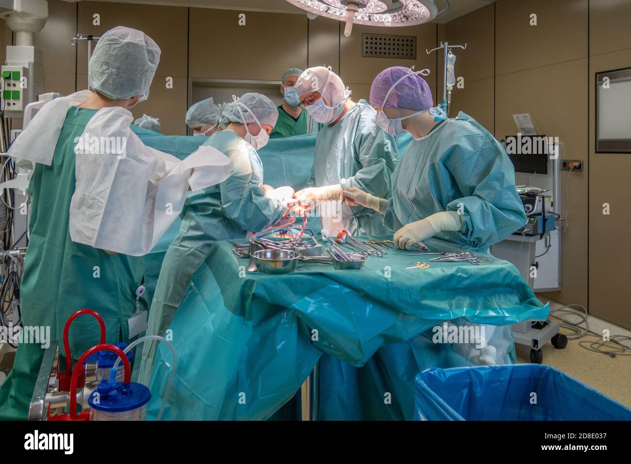 a team of gynecologists performs a caesarean section in an operating ...