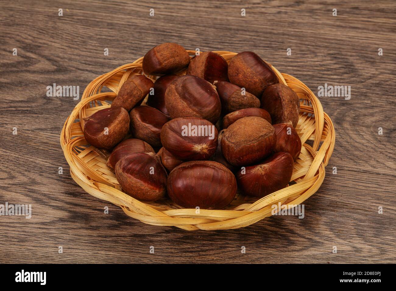 Chestnut heap in the bowl over wooden background Stock Photo - Alamy