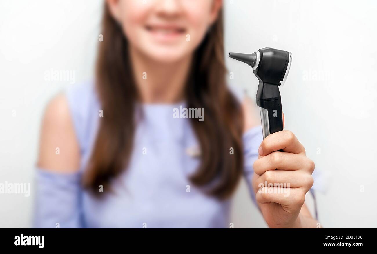 Otoscope in hand of a teenage girl, close-up. Concept ear treatment and ...