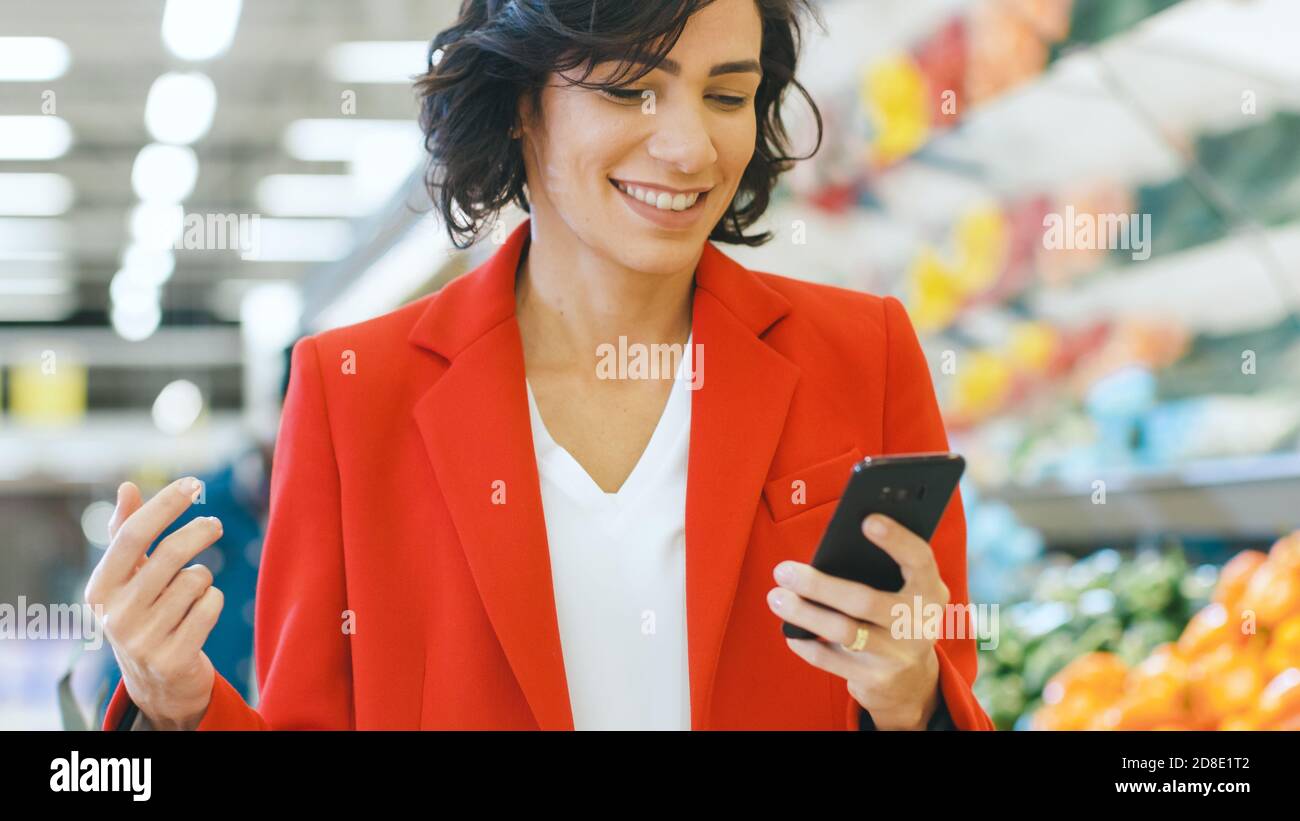 At the Supermarket: Portrait of a Beautiful Young Happy Woman Uses ...