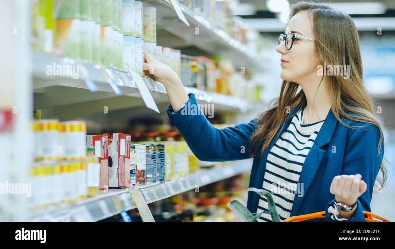 At the Supermarket: Beautiful Young Woman Browses through the Canned ...