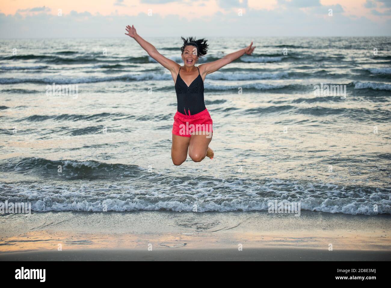 Woman leaping sea hi-res stock photography and images - Alamy
