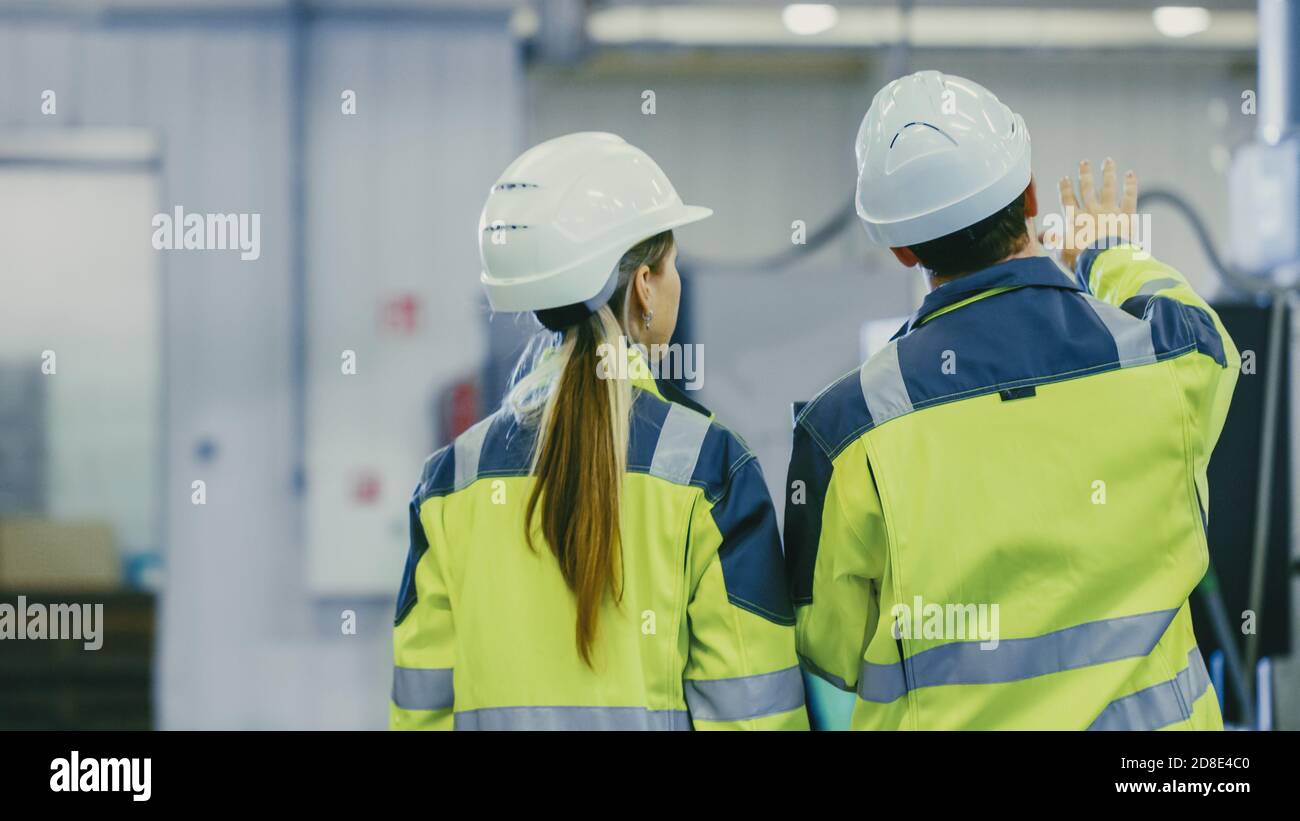 Male Industrial Worker and Female Chief Mechanical Engineer in Walk ...