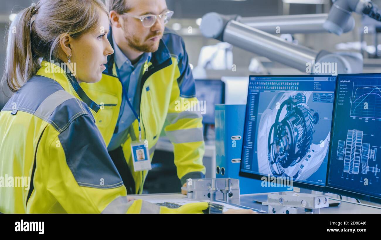 At the Factory: Male Mechanical Engineer and Female Chief Engineer Work ...