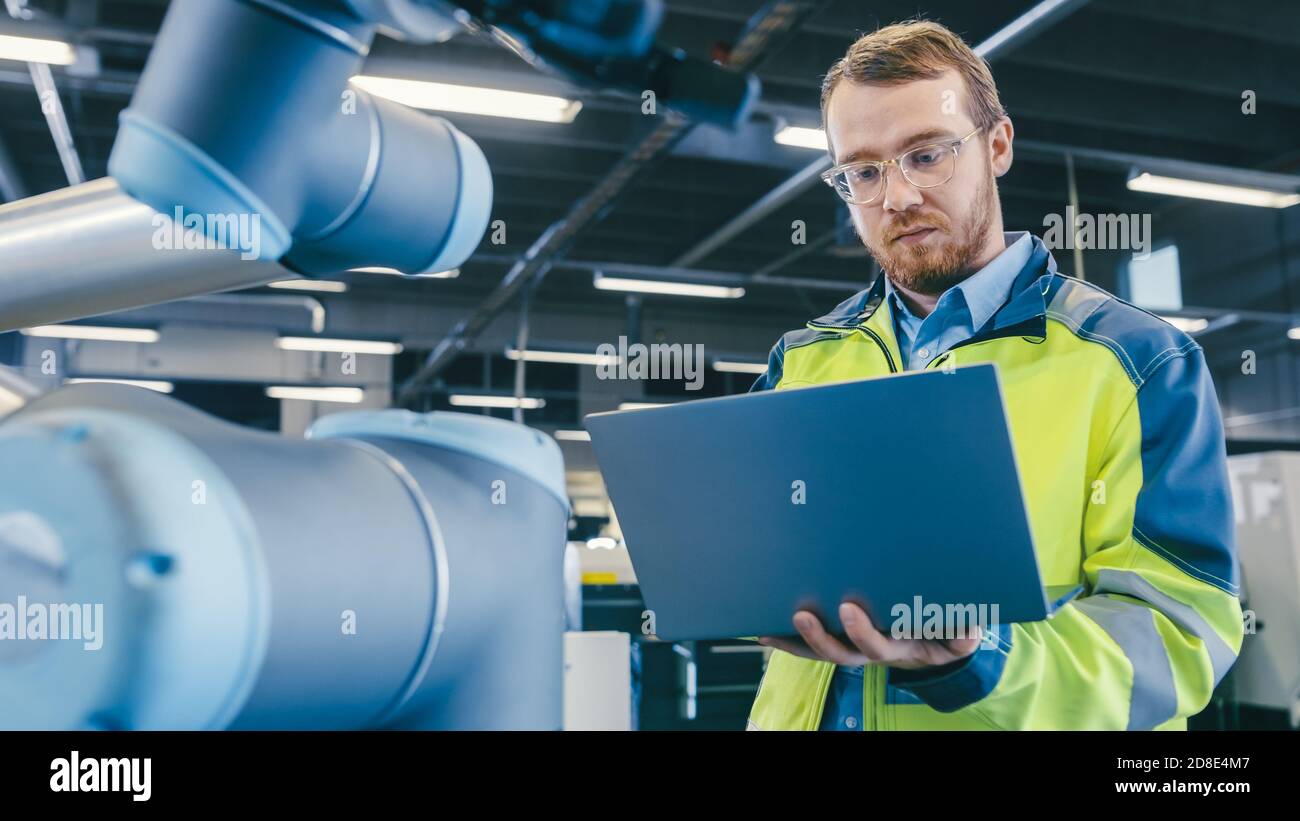 Uses laptop for programming robotic arm hi-res stock photography and ...