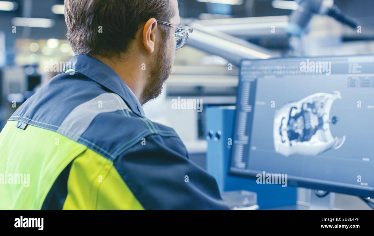 Back Shot of an Mechanical Engineer Working on Computers, Designing in 3D Model of the Engine ...