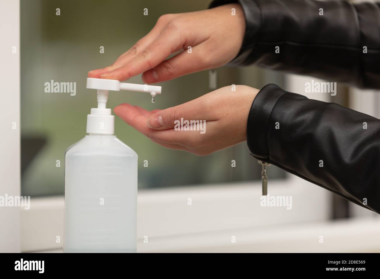 Female hand pressing bottle and pouring alcohol-based sanitize on hands ...