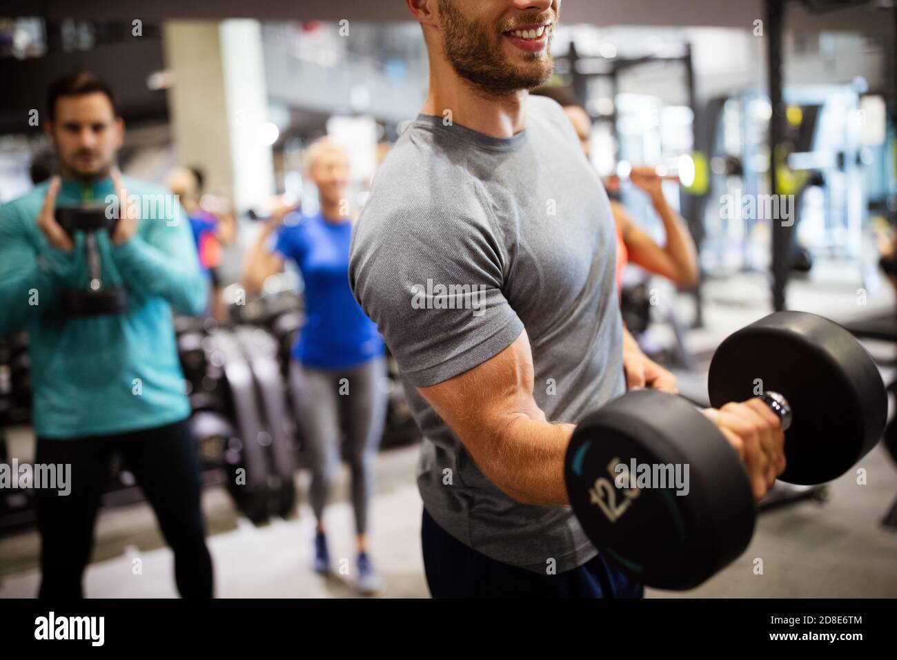 Group of young happy fit people doing exercises in gym Stock Photo - Alamy
