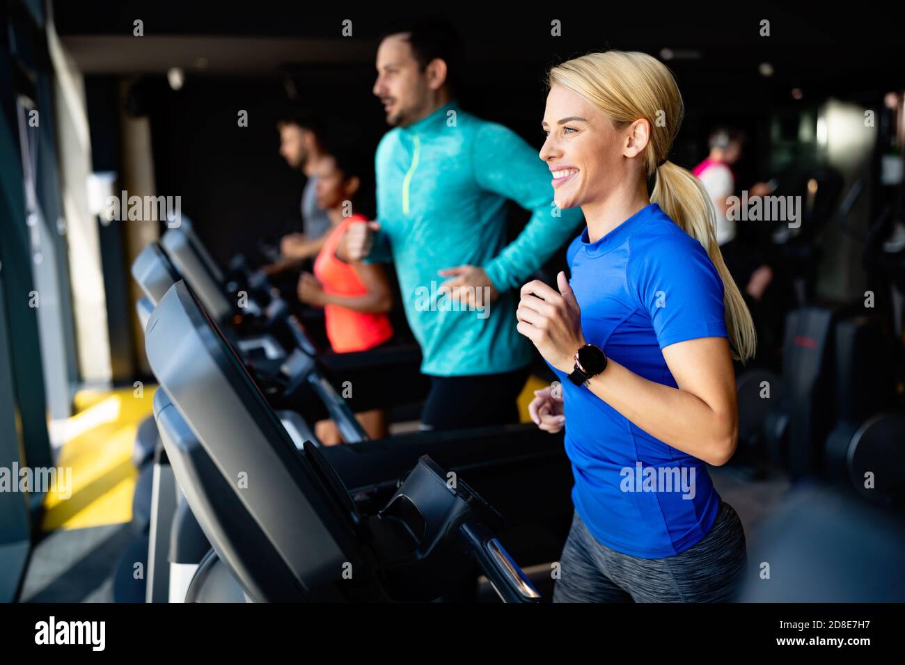 Young people running on a treadmill in modern gym Stock Photo - Alamy