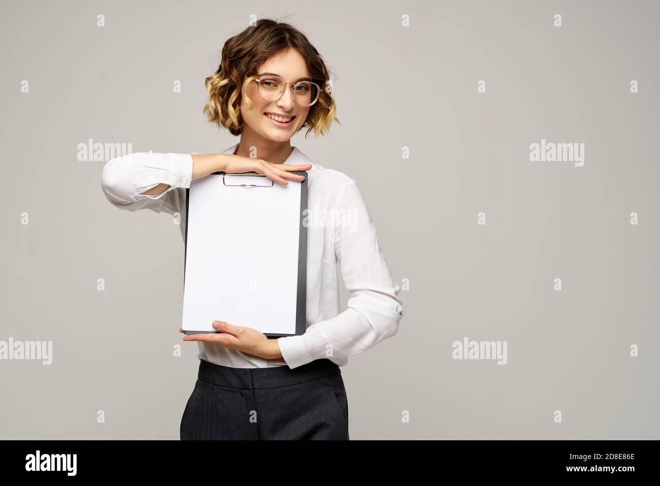 Business woman with folder of documents in hands on gray background ...