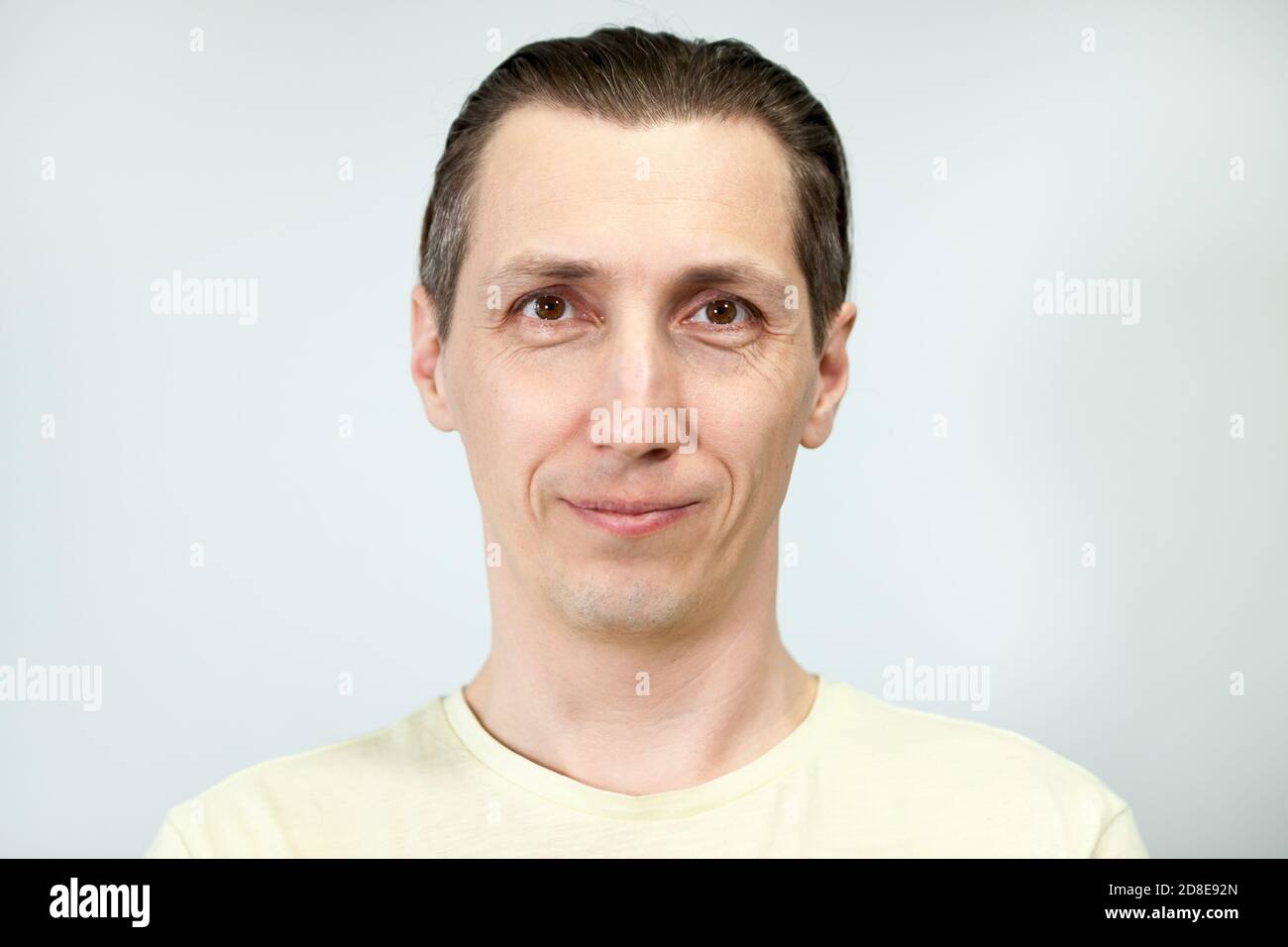 Portrait of a smiling and calm man, grey background, emotions series ...