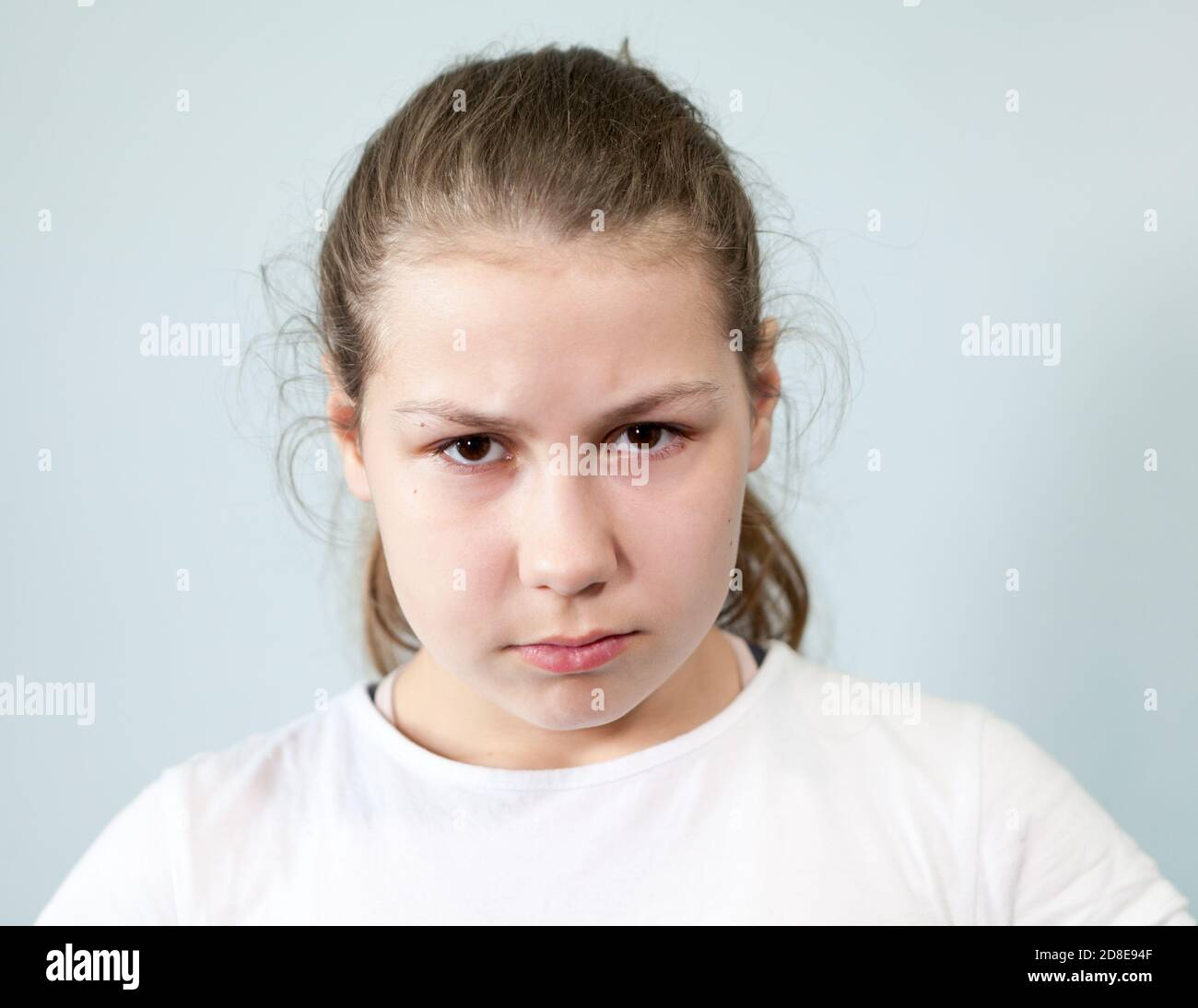 Caucasian pre-teen girl with frowning eyebrows and heavy look, angry ...