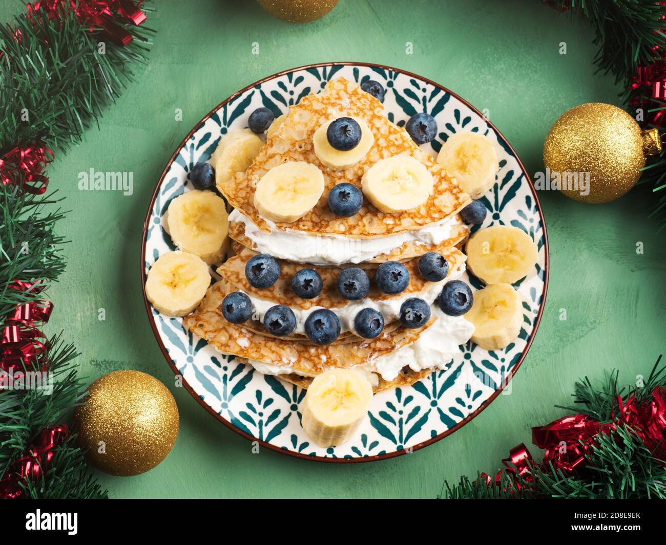 Christmas tree shaped crepes with blueberry, quark Stock Photo - Alamy