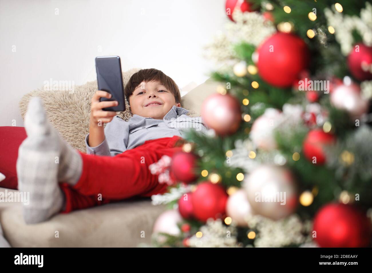 merry christmas, child at home with mobile phone near the illuminated ...