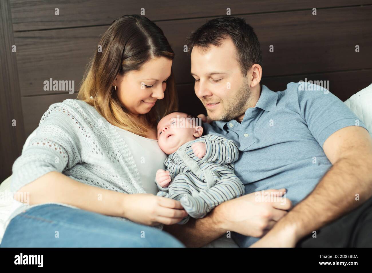 A beautiful couple with newborn Baby on bed Stock Photo - Alamy