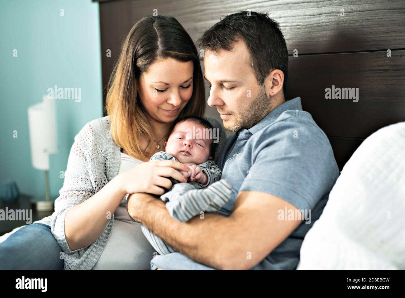 A beautiful couple with newborn Baby on bed Stock Photo - Alamy