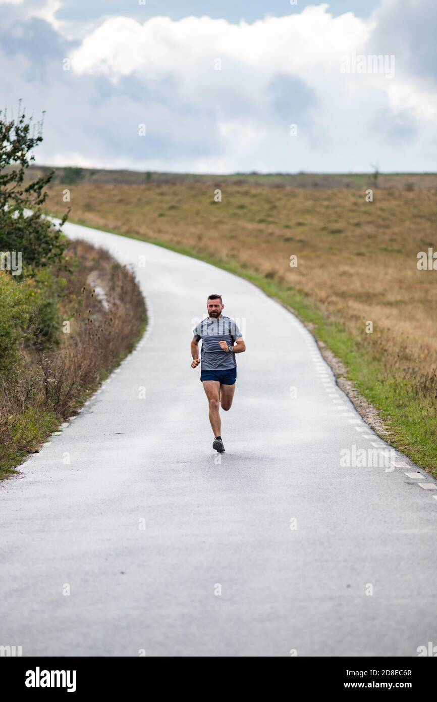 young man running on country road Stock Photo - Alamy