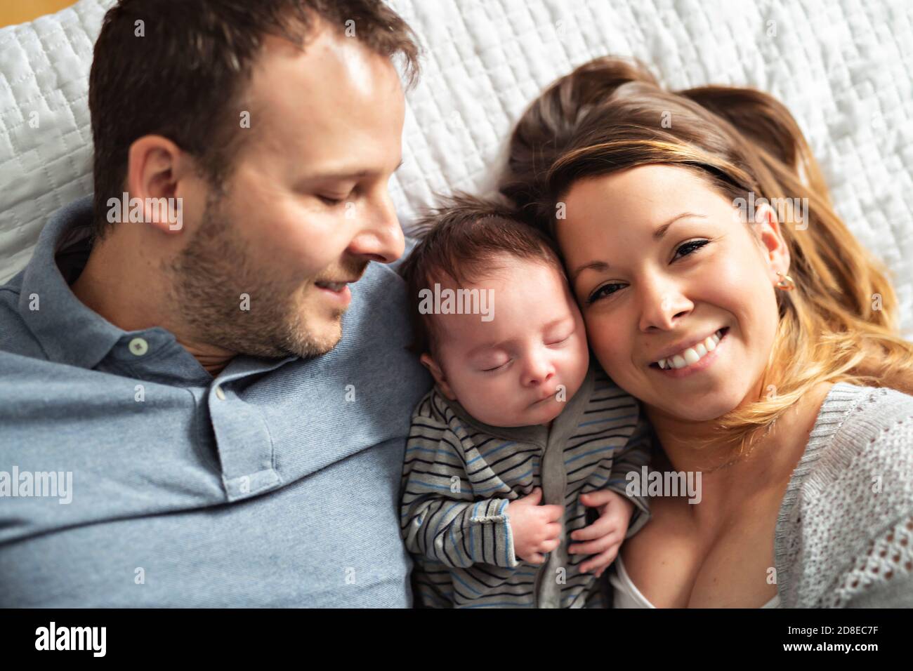 A beautiful couple with newborn Baby on bed Stock Photo - Alamy