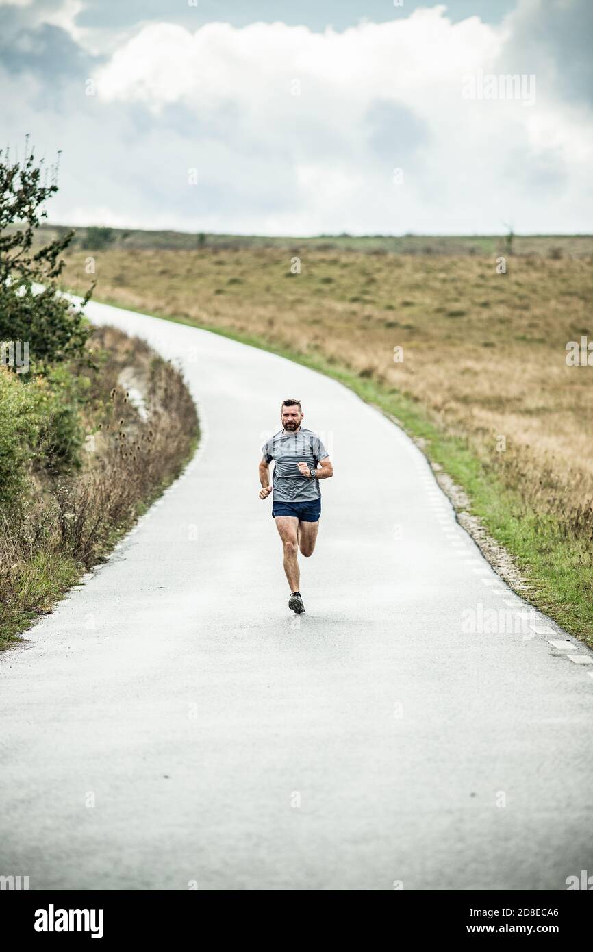 young man running on country road Stock Photo - Alamy