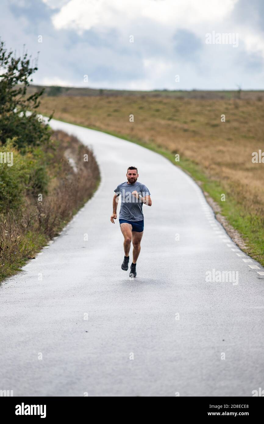 young man running on country road Stock Photo - Alamy