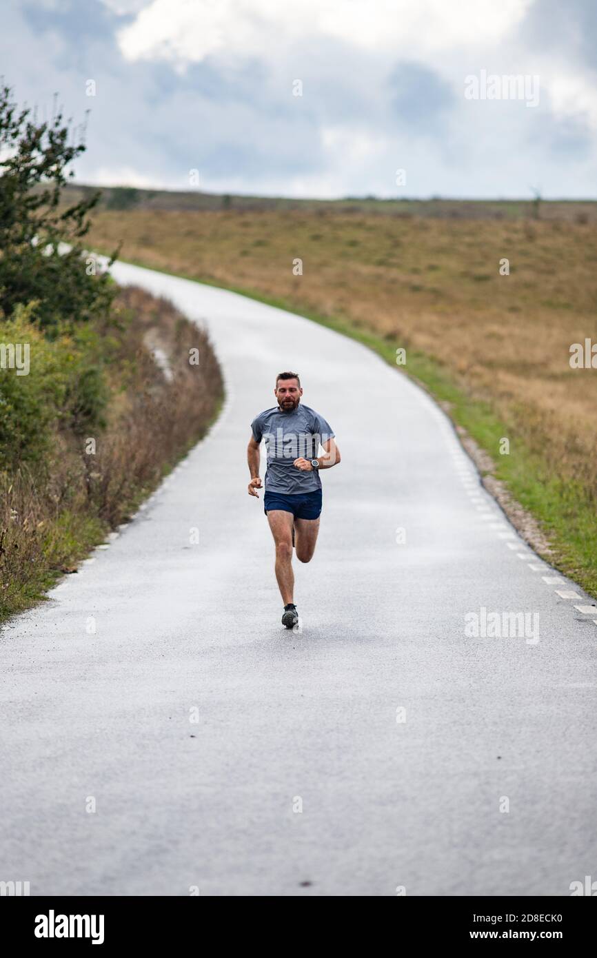young man running on country road Stock Photo - Alamy