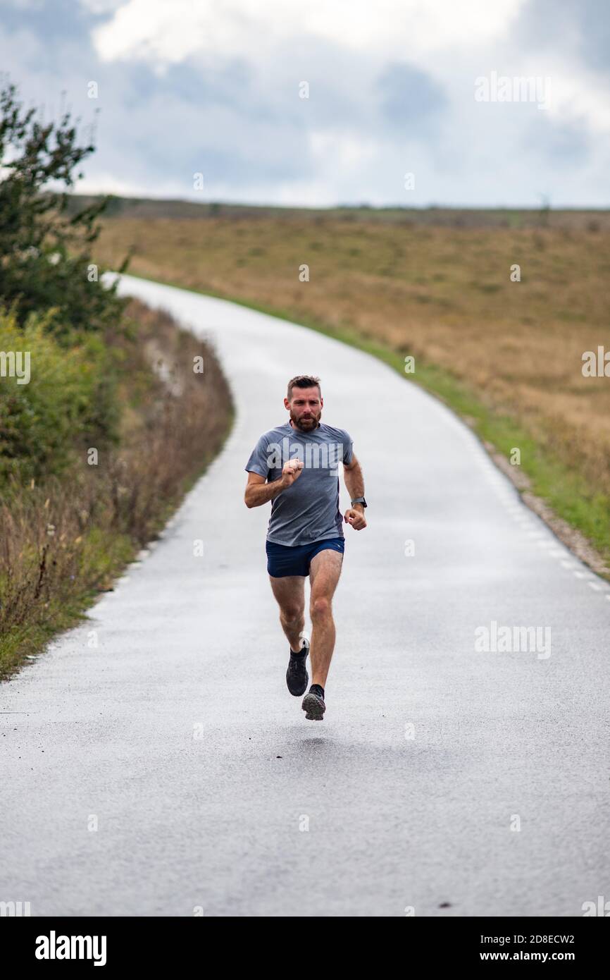 young man running on country road Stock Photo - Alamy
