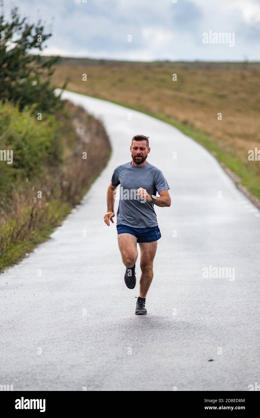 Young man jogging on rural road hi-res stock photography and images - Alamy