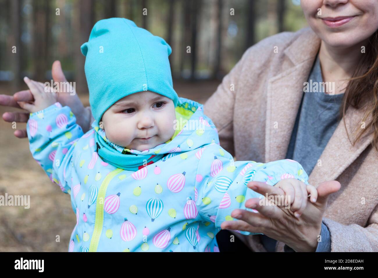 Toddler child stepping with mother support, female hands holding child ...