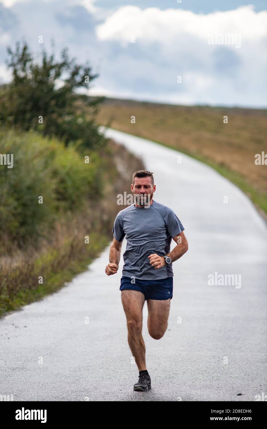 Young man jogging on rural road hi-res stock photography and images - Alamy