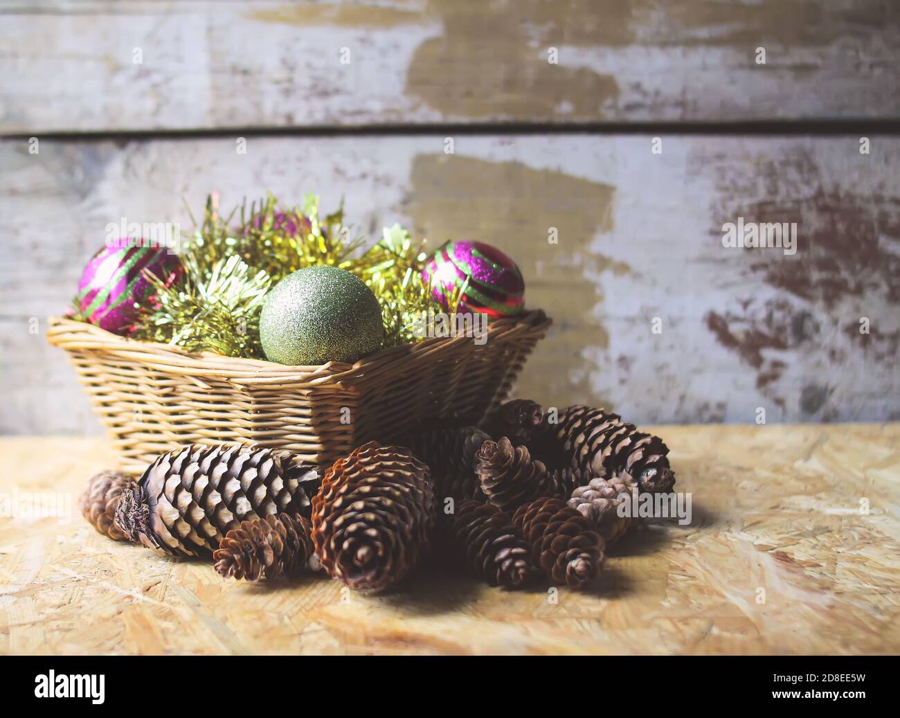 Fir-tree cones and christmas decorations in a small basket on aged ...
