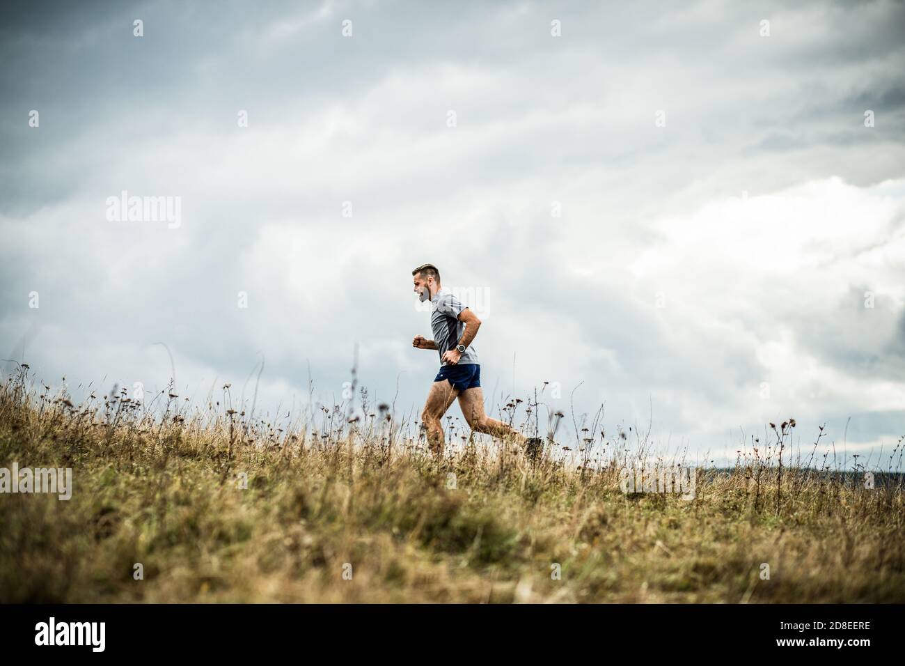 handsome trail runner running in nature Stock Photo - Alamy