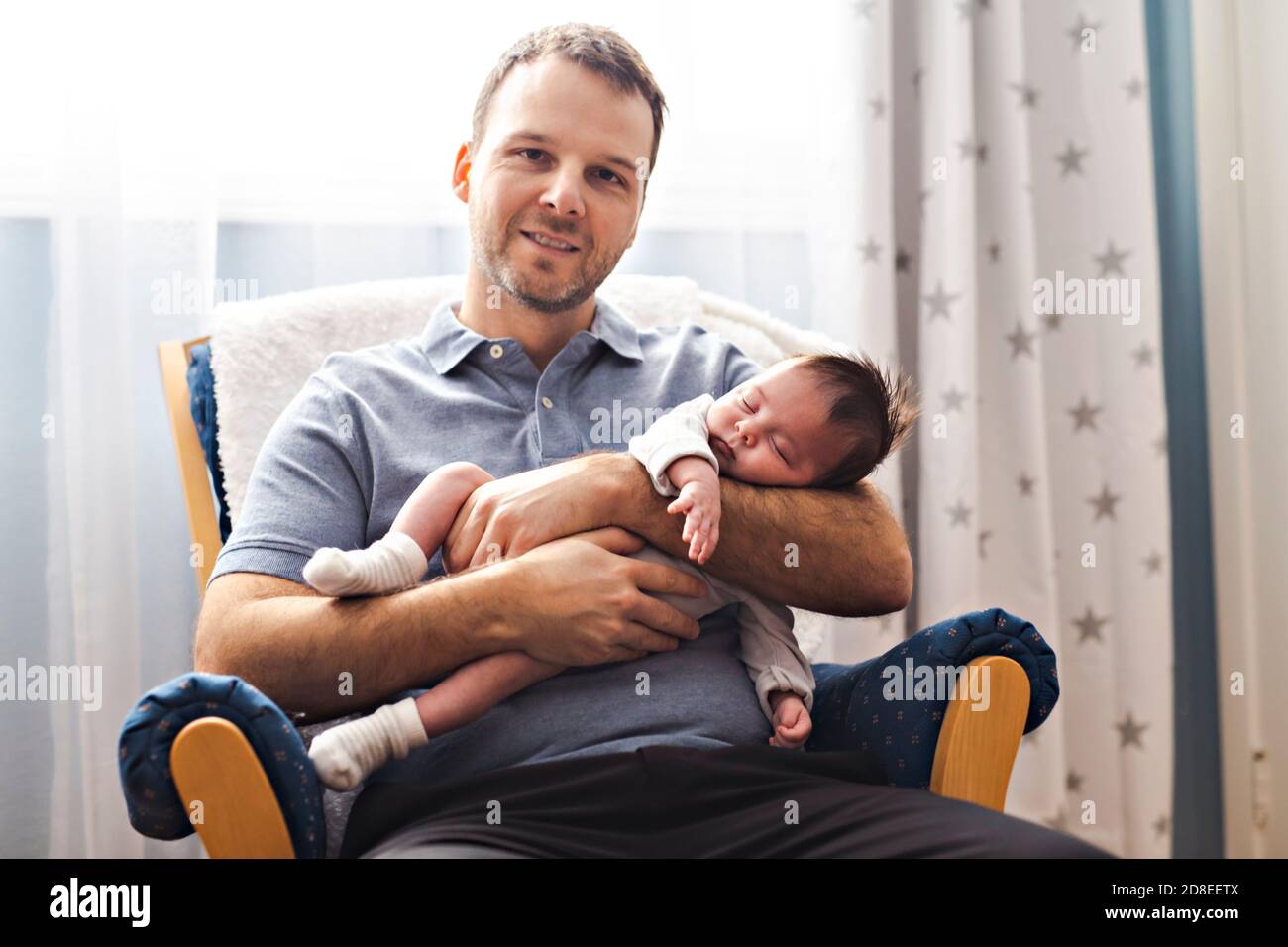Father and Baby having wonderful time sit on chair one the bedroom ...