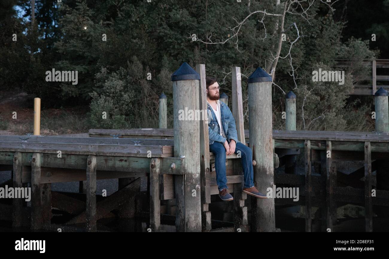 Man sitting on dock hi-res stock photography and images - Alamy