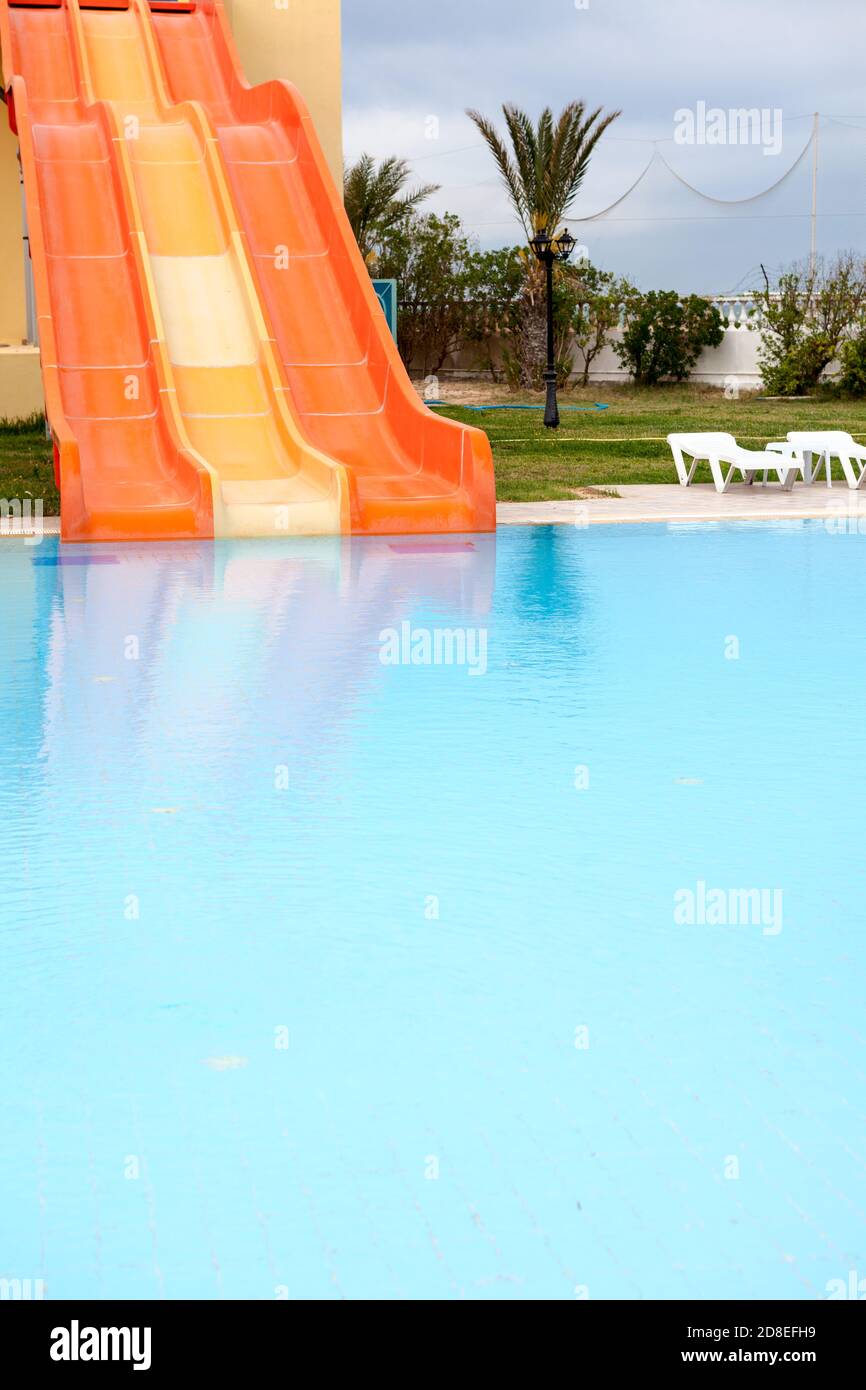 Closed water slides are in waterpark in a hotel, calm water surface of ...