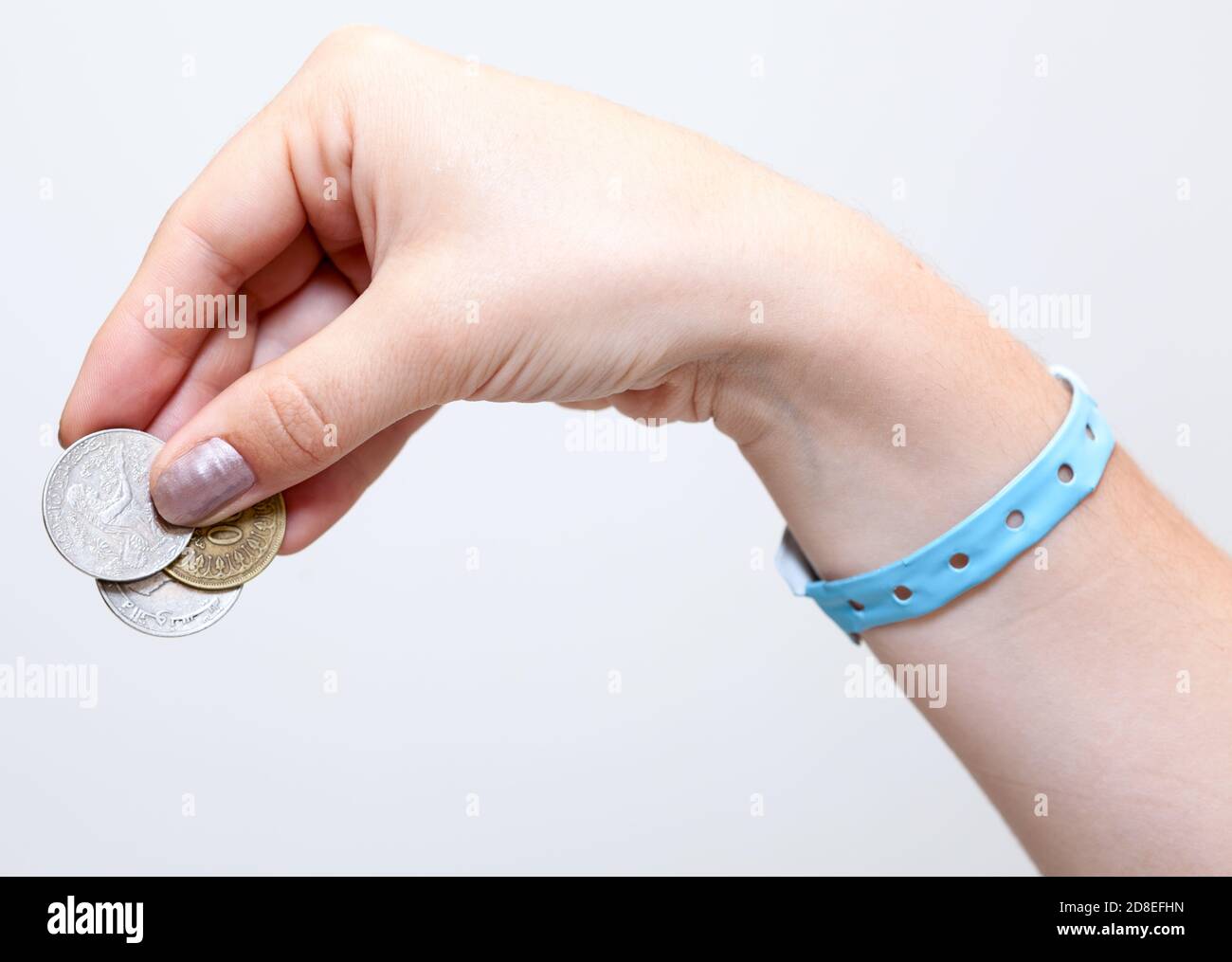 Female hand gives tip with coins money, grey background Stock Photo - Alamy