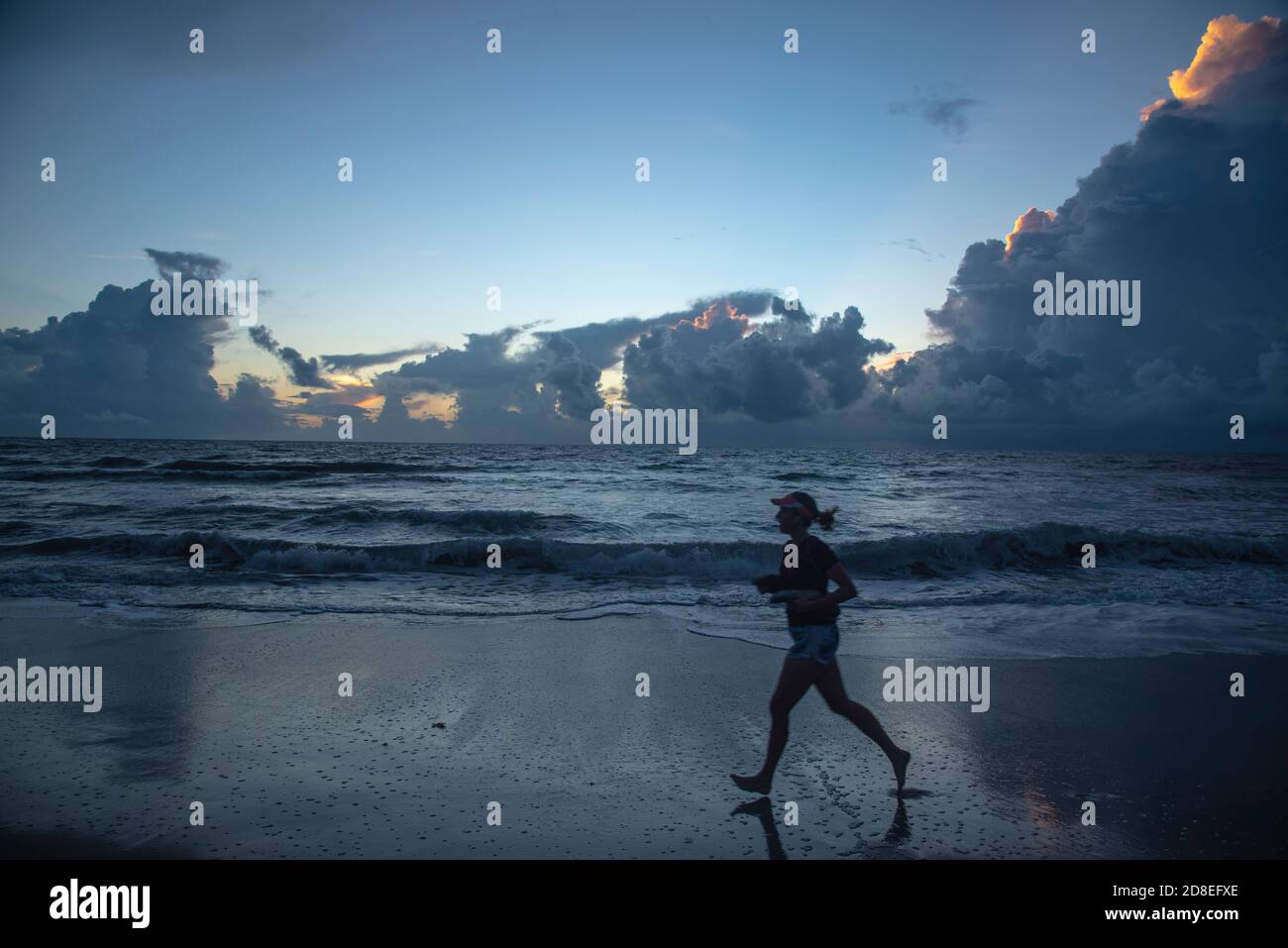 Beach runner at sunrise Stock Photo - Alamy