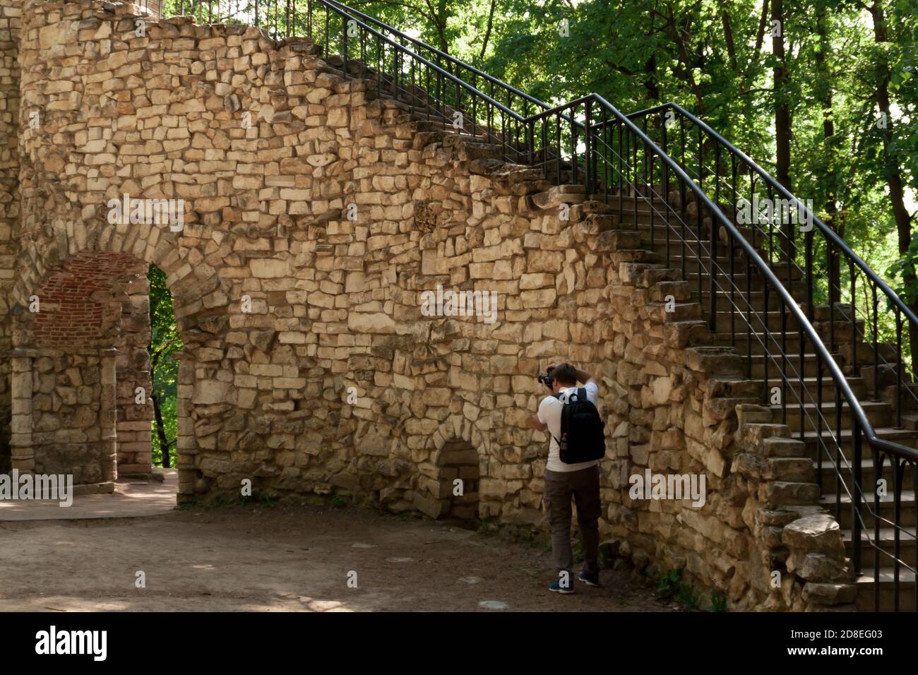 Young man photorgapher at work. Cameraman makes a photo of an ancient ...
