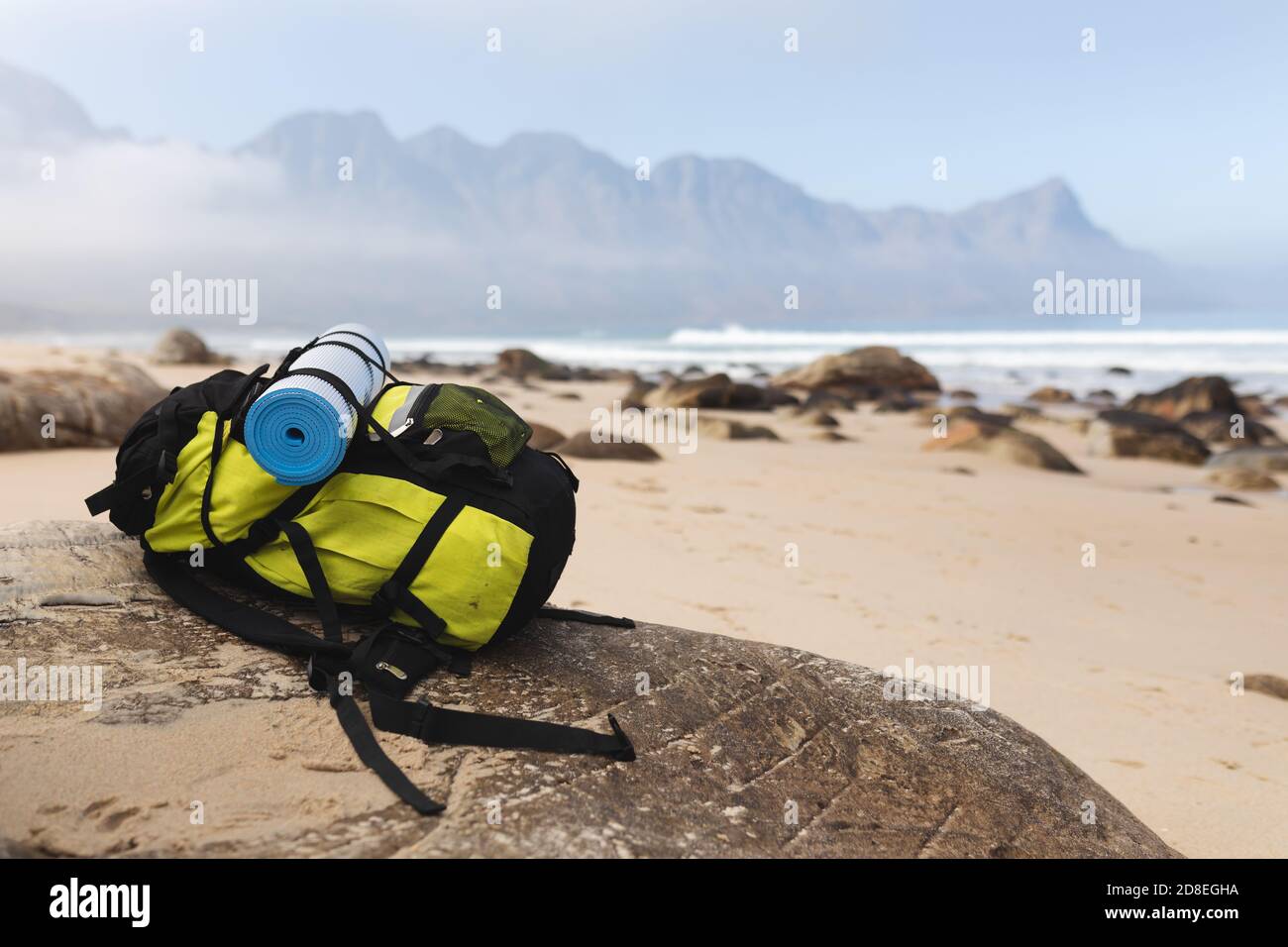 Image of a backpack lying on a rock on a beach by a calm sea Stock ...